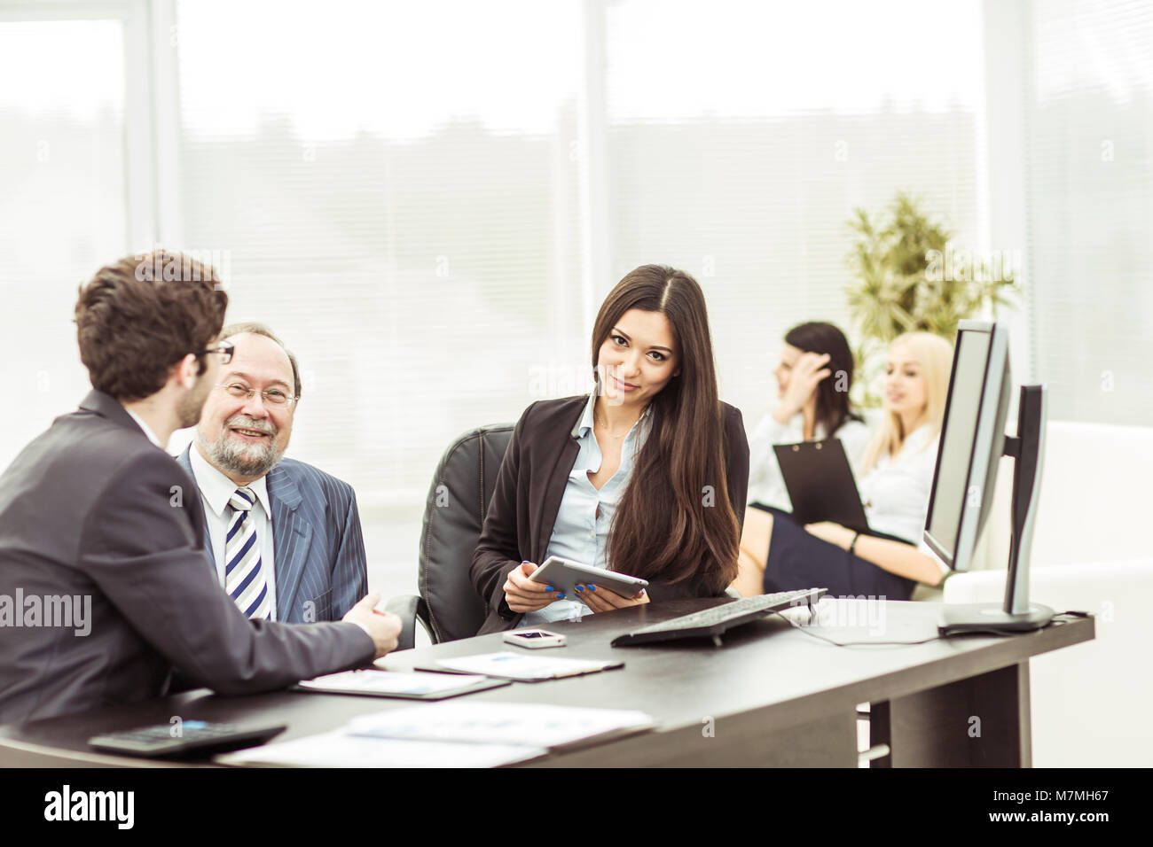 boss and members of the business team sitting at workplace on ...
