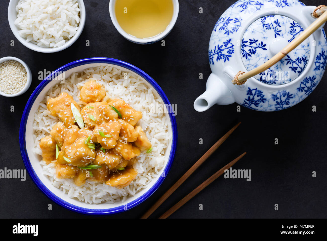 Chicken with rice, sesame seeds and green tea on black stone background ...
