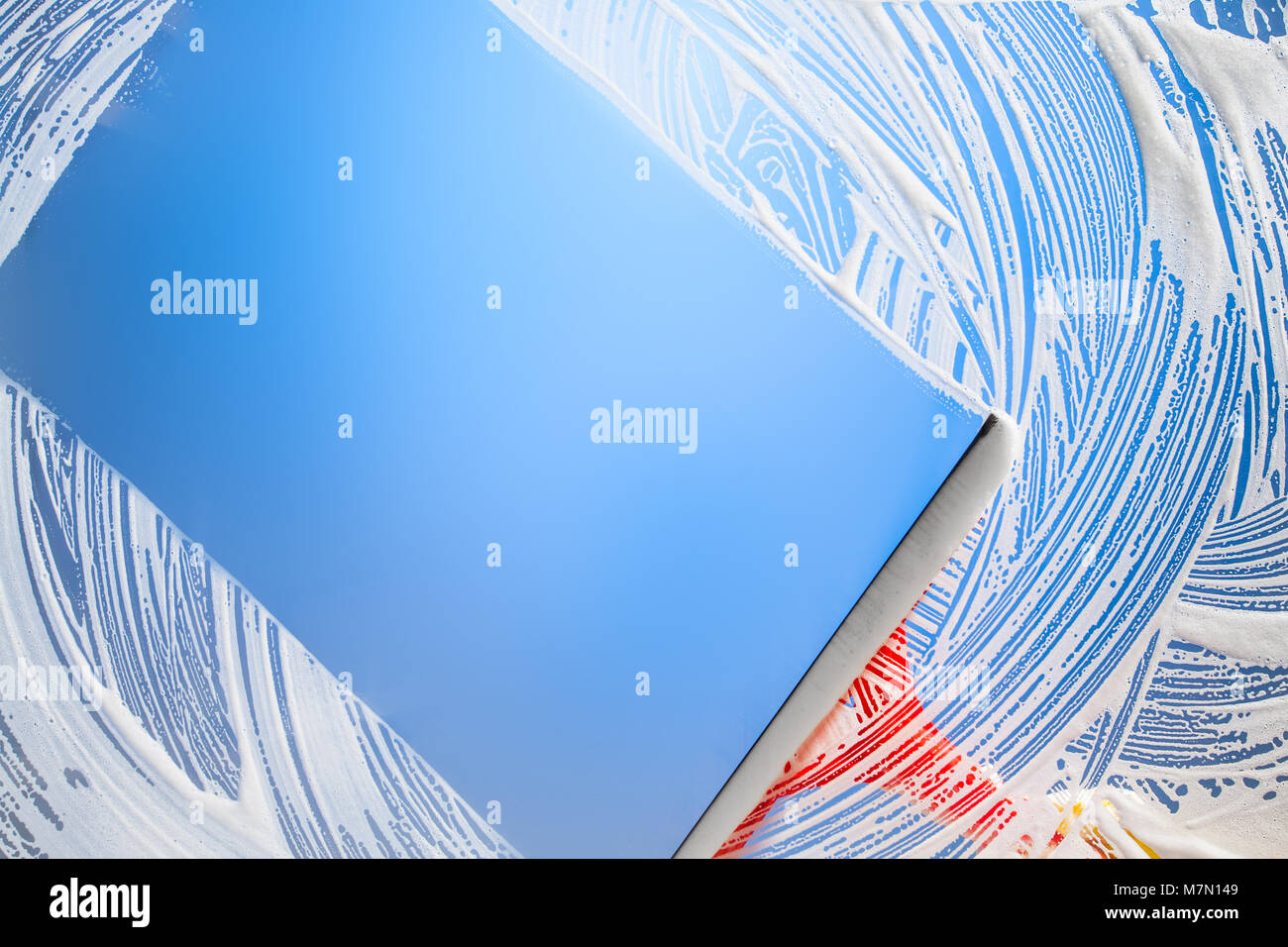 cleaning window with squeegee blue sky. studio shot Stock Photo - Alamy