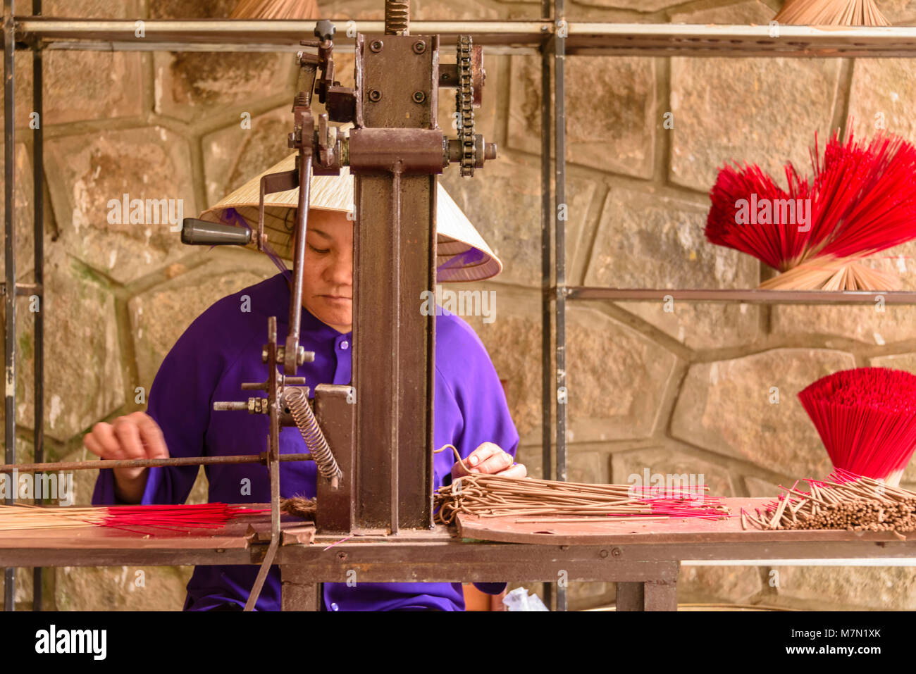 A Vietnamese woman wearing a traditional bamboo conical hat makes ...