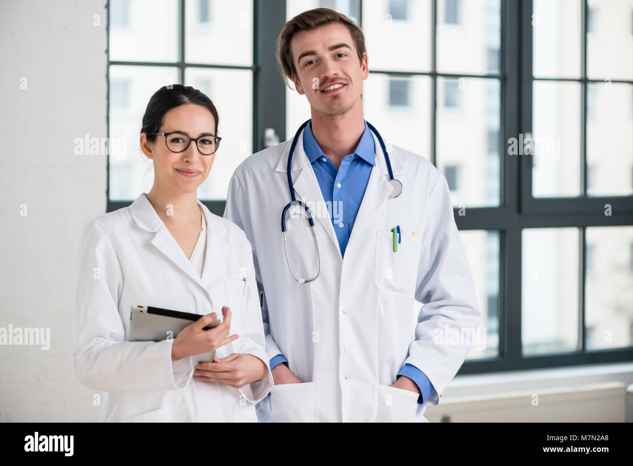 Two dedicated doctors smiling at camera Stock Photo - Alamy