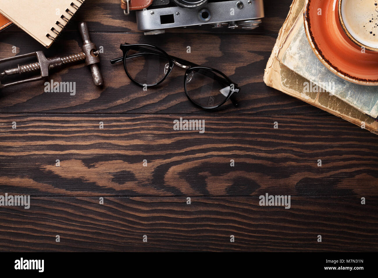 Retro table with vintage items. Old books, glasses, camera, coffee cup ...