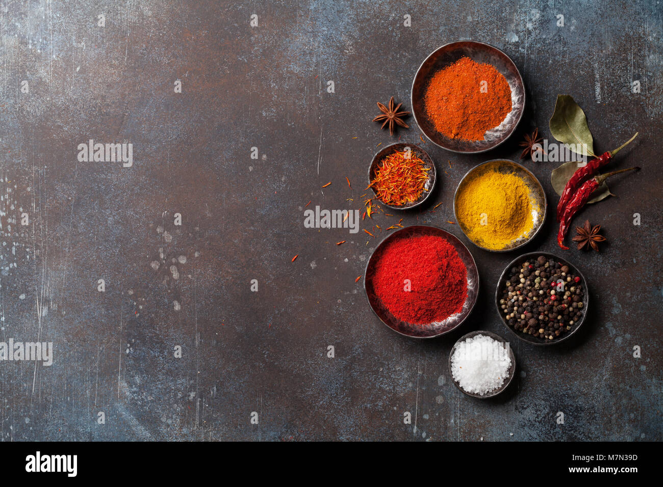 Colorful spices on stone table. Top view with space for your recipe ...