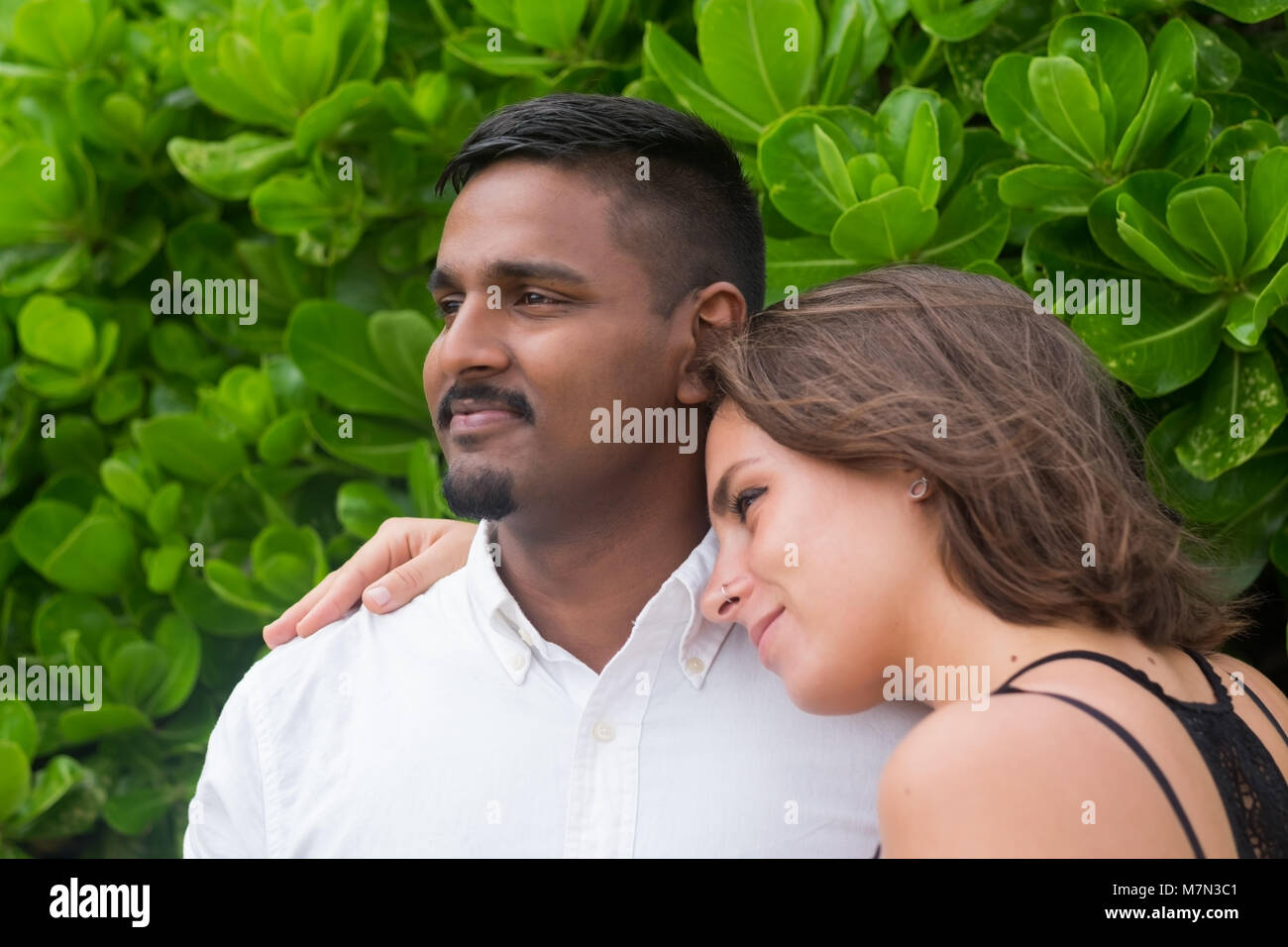 happy young mix raced couple on green background Stock Photo - Alamy