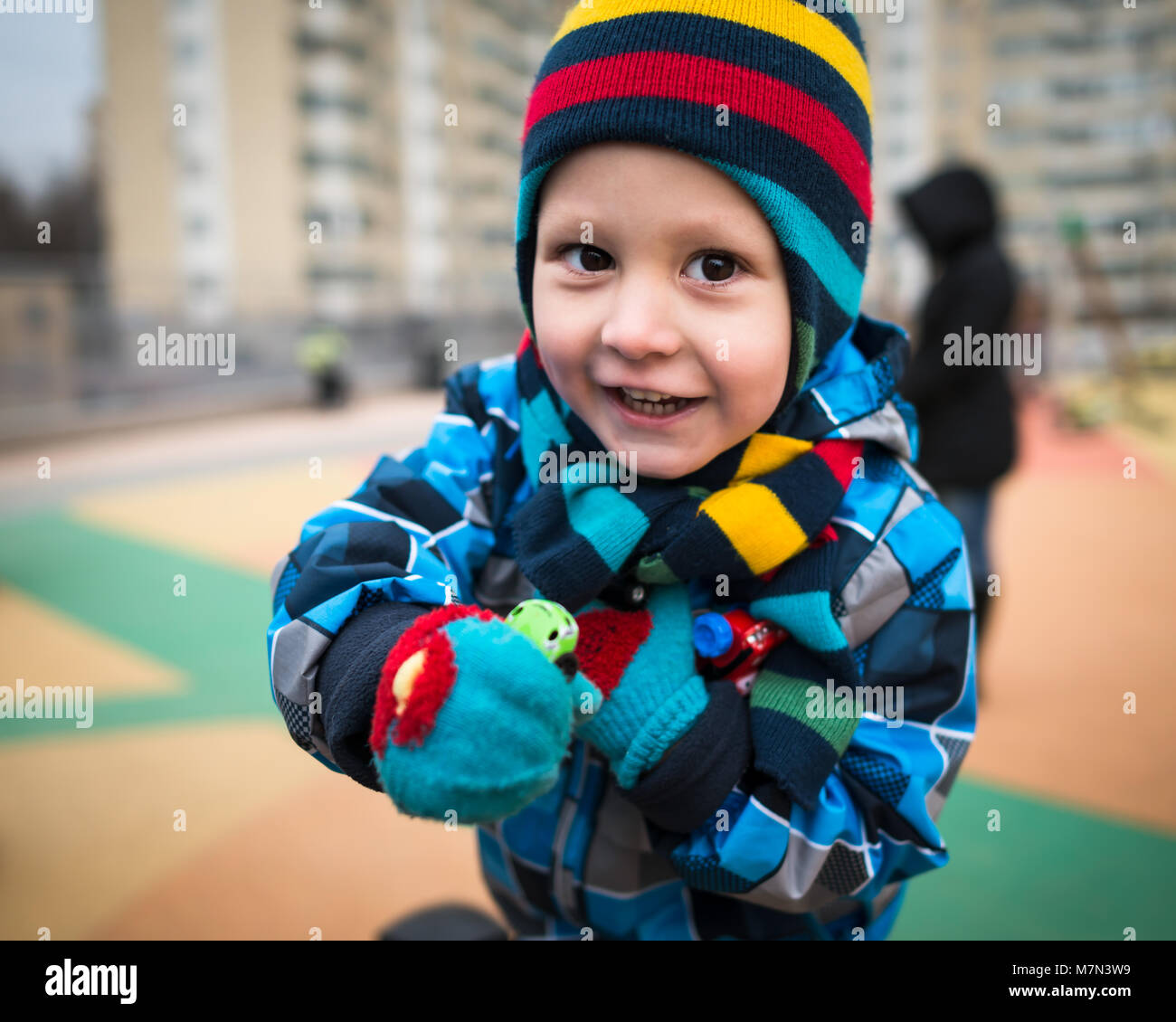 Cheerful little boy runs around on the playground and has fun ...
