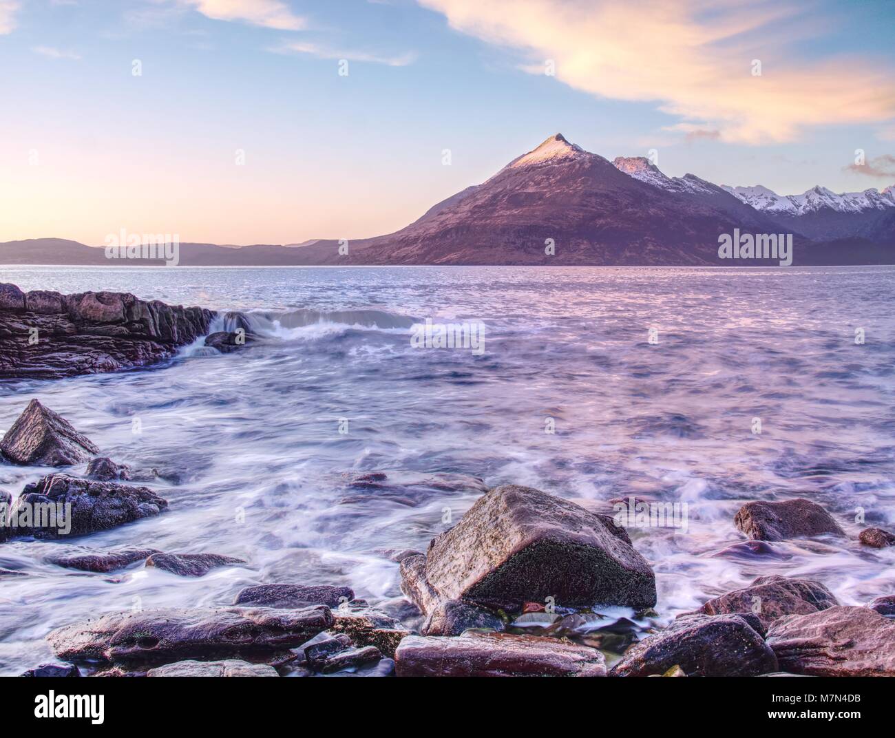 Evening rocky shore with sea water and large cracked rocks with erosion ...