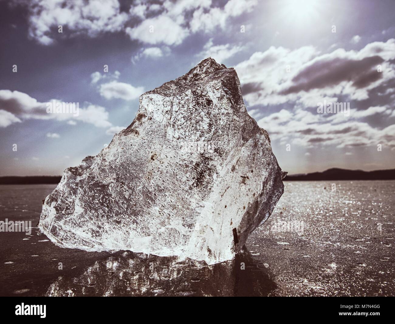 Sharp piece of ice. A symbol of harsh winter. The rays of the sun form ...