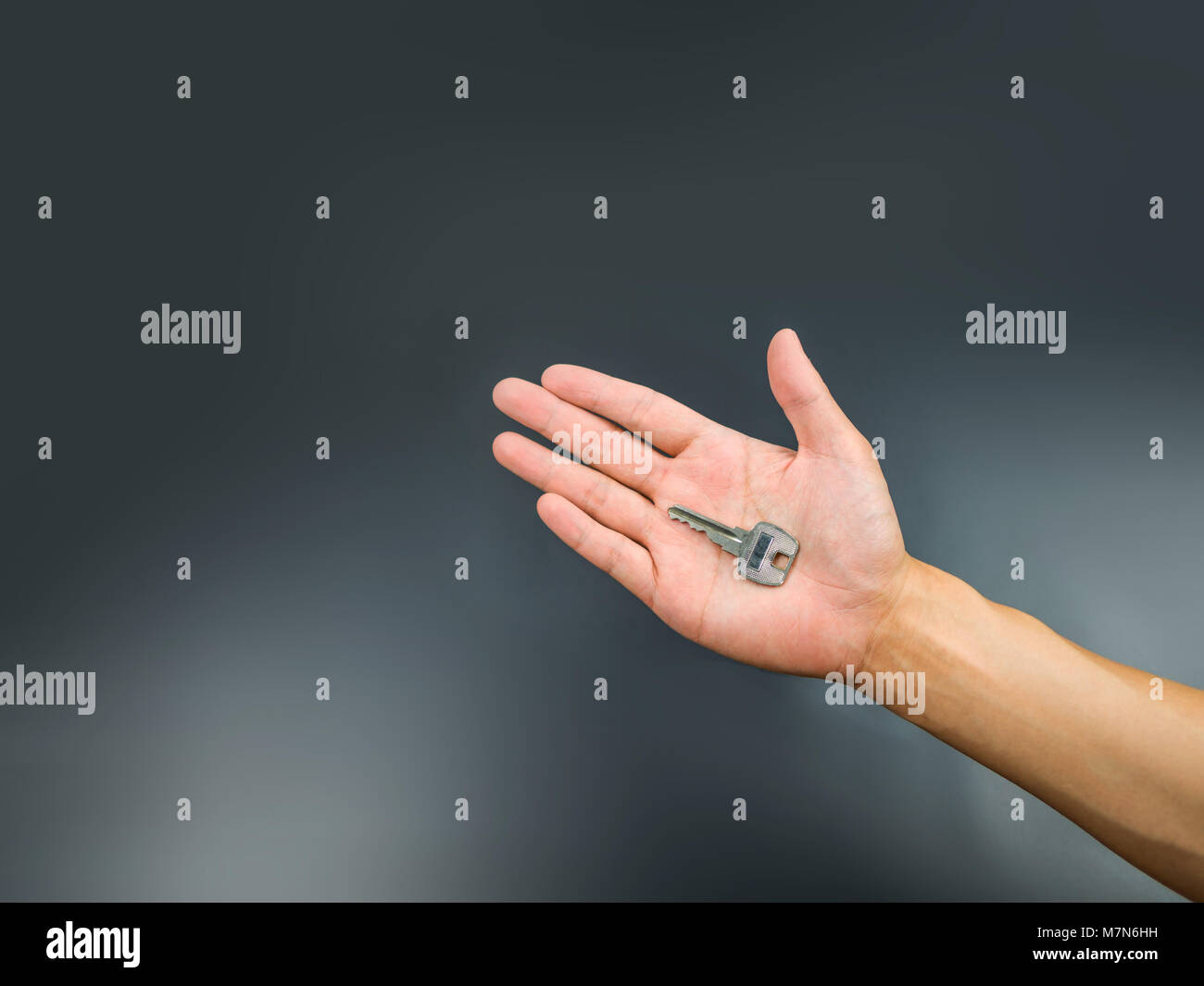 Key on hand on dark background Stock Photo - Alamy