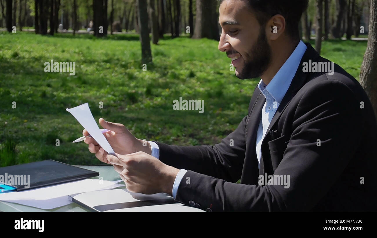 Freelancer doing paper work and talking on phone Stock Photo - Alamy