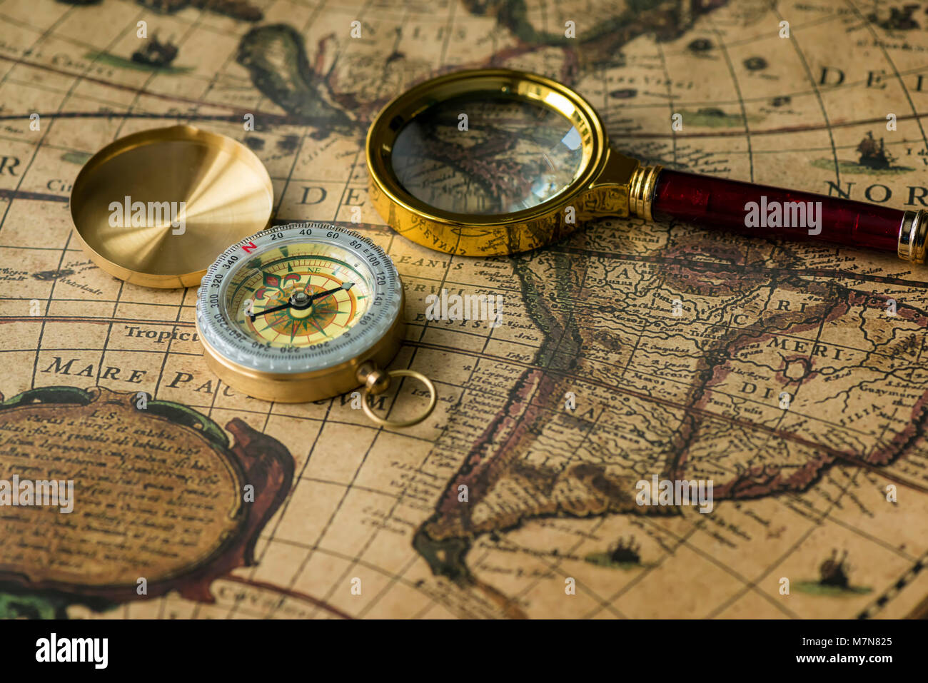 Retro compass with old map and magnifier closeup Stock Photo - Alamy