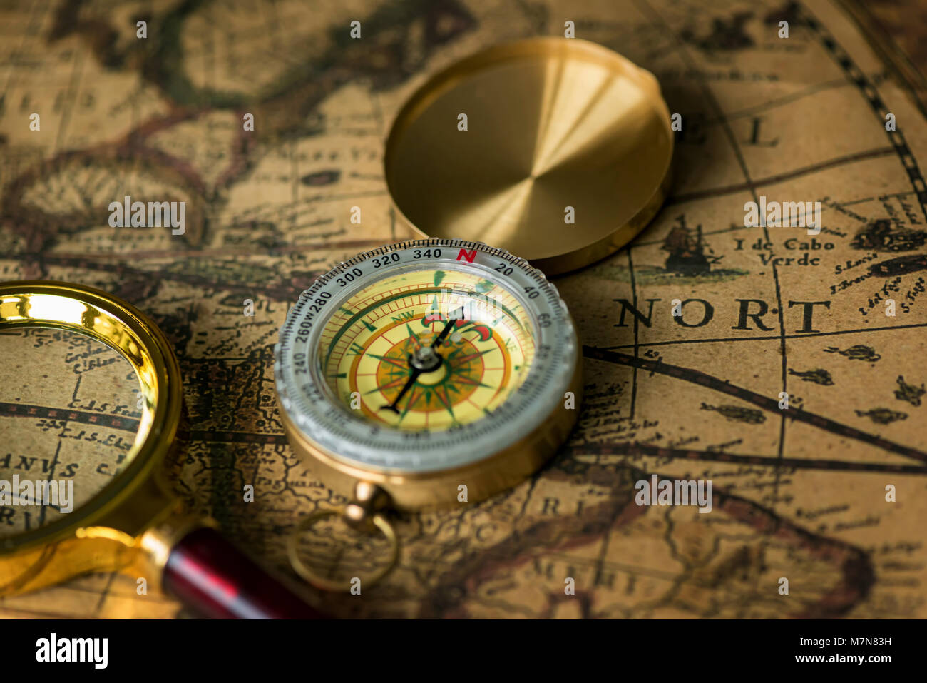 Retro compass with old map and magnifier closeup Stock Photo - Alamy