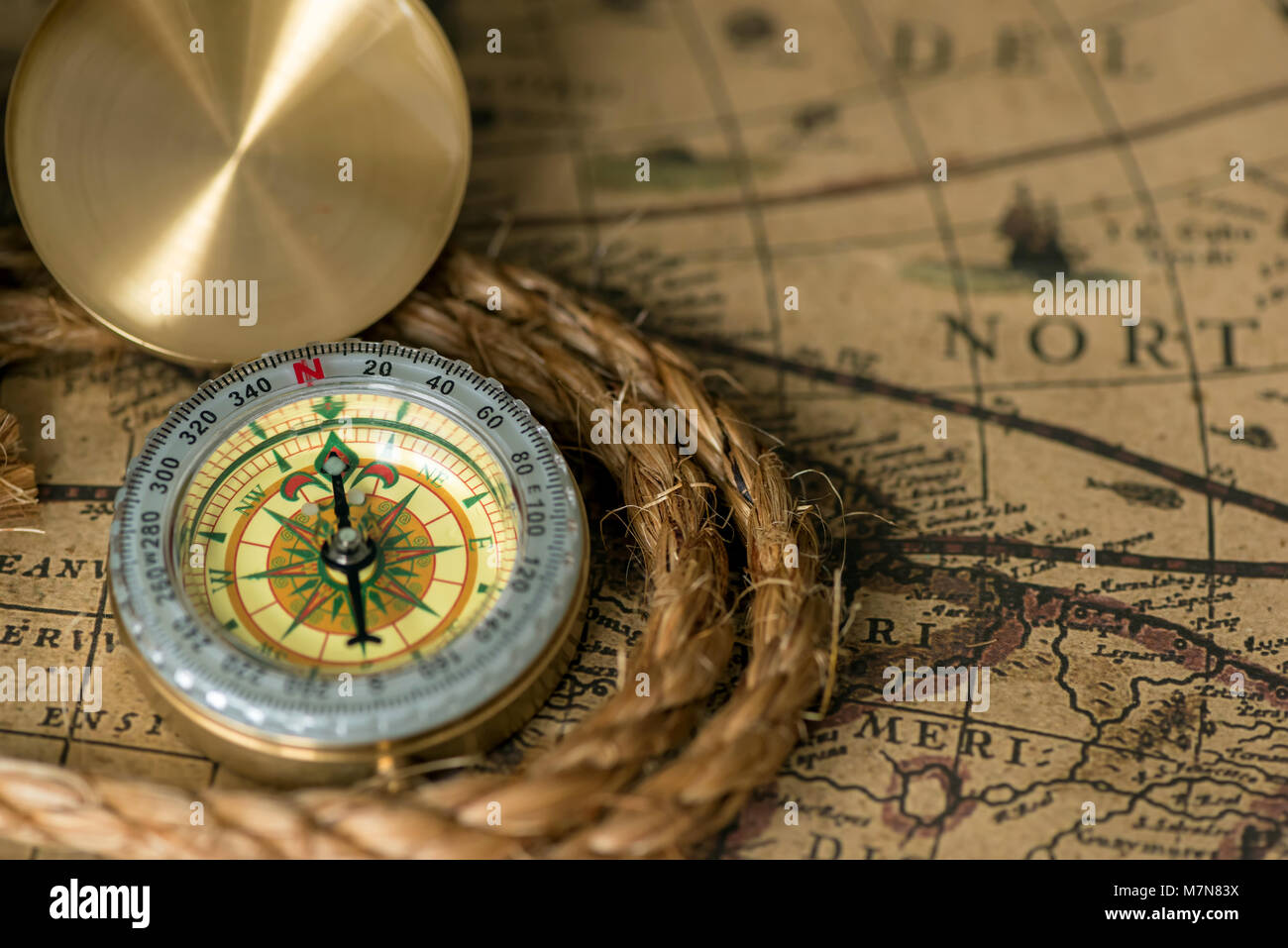 Old compass on vintage map with rope closeup. Retro stale Stock Photo ...