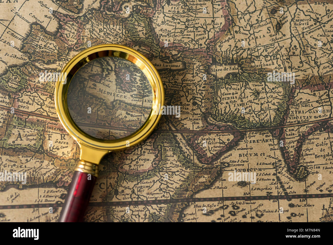 Retro magnifier with old map closeup Stock Photo - Alamy
