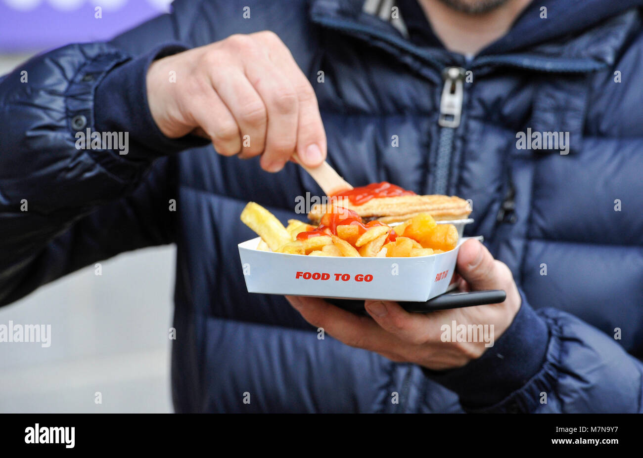 Football fan with Pie and chips with tomato sauce fast food takeaway ...