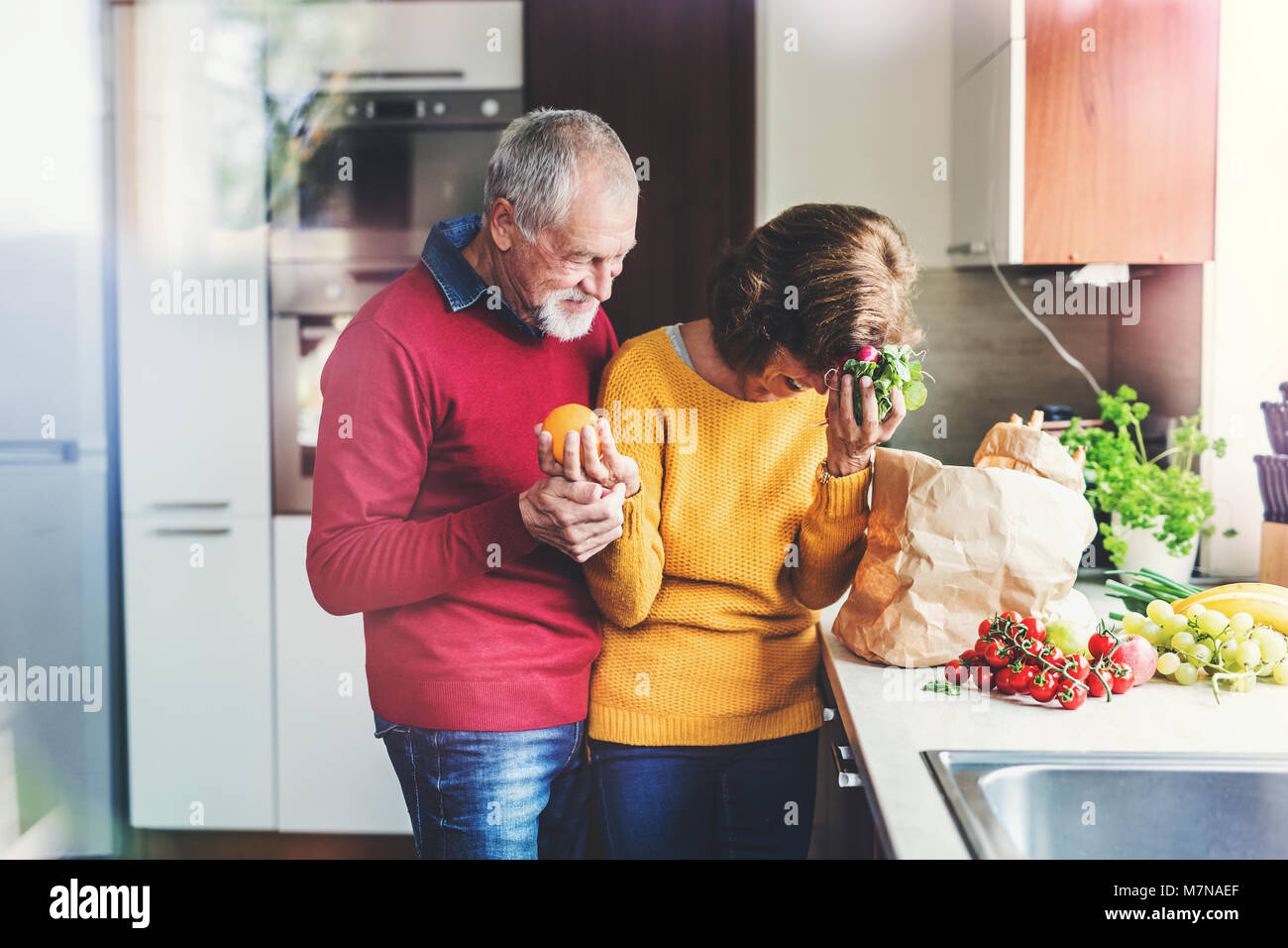 Senior couple unpacking food in the kitchen Stock Photo - Alamy