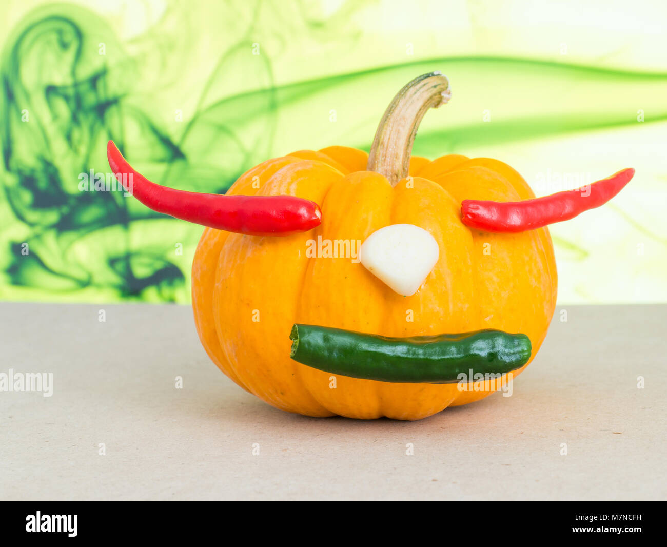 pumpkin on color abstract green background, red chili in pumpkin ...