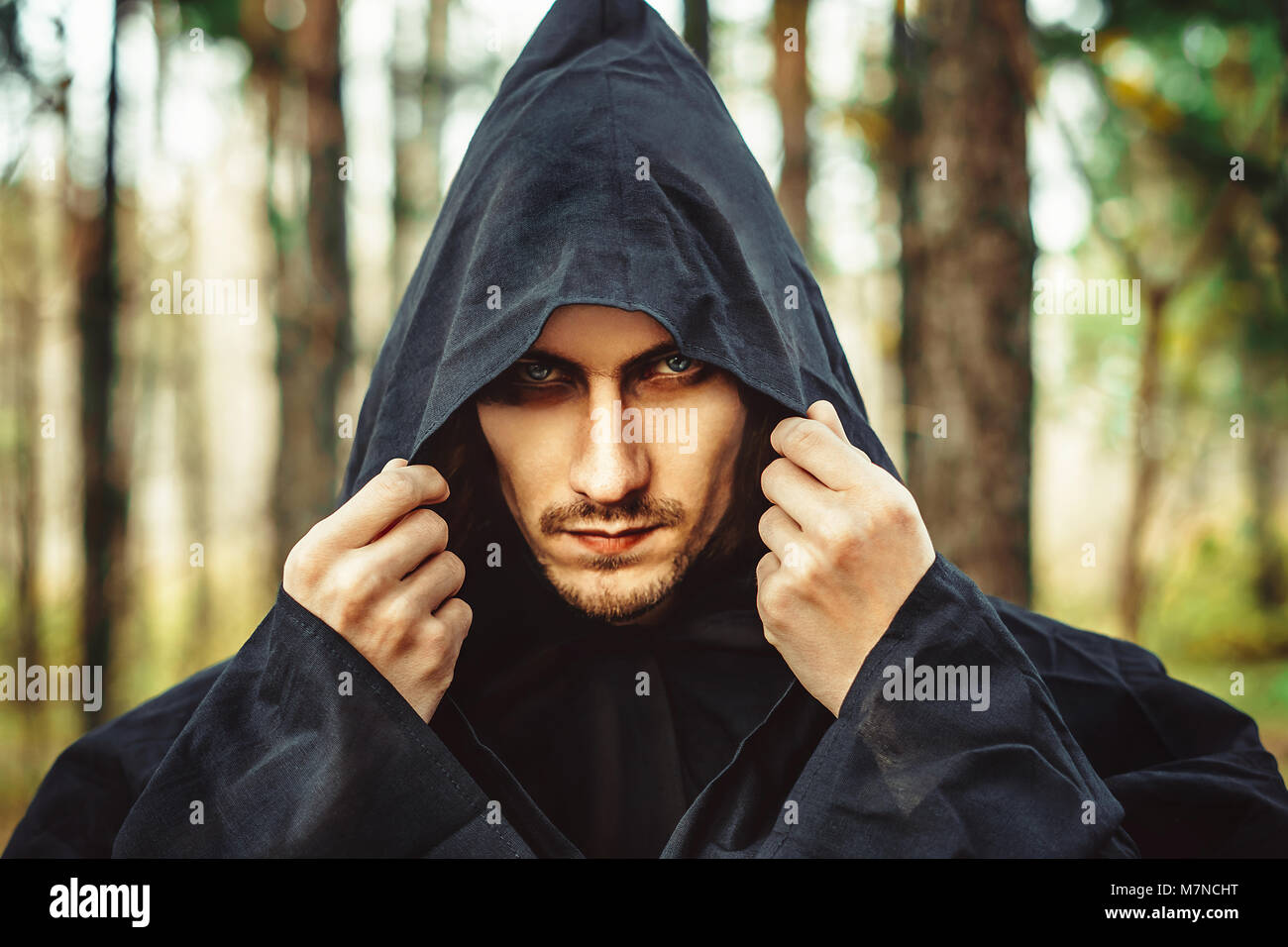 the guy in the black robe, standing in the dusk in the woods Stock ...