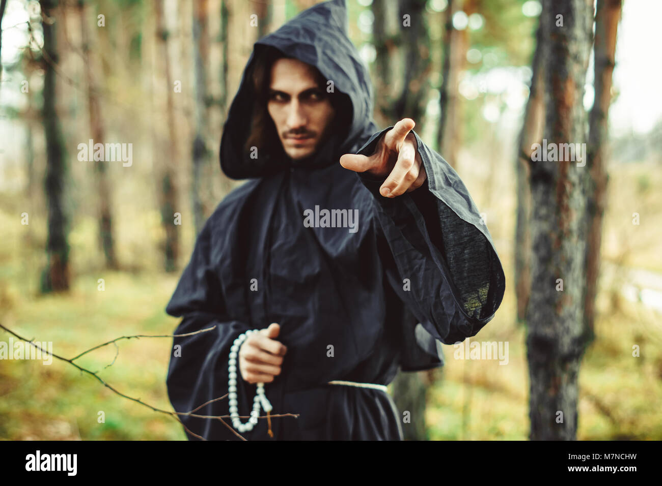 the black monk pointing his finger in the woods Stock Photo - Alamy