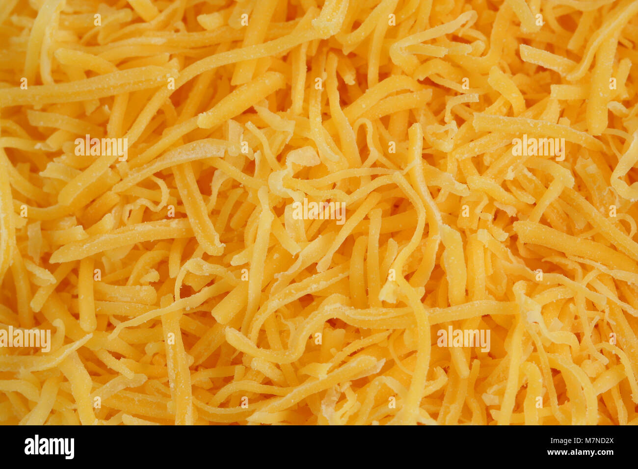 A Shredded cheddar cheese background Stock Photo - Alamy