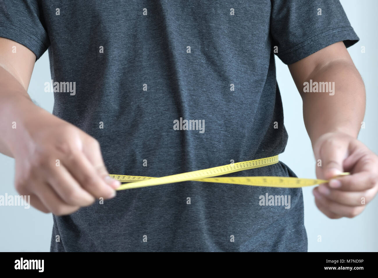 man Checking Waistline body shape waist measure tape Stock Photo - Alamy