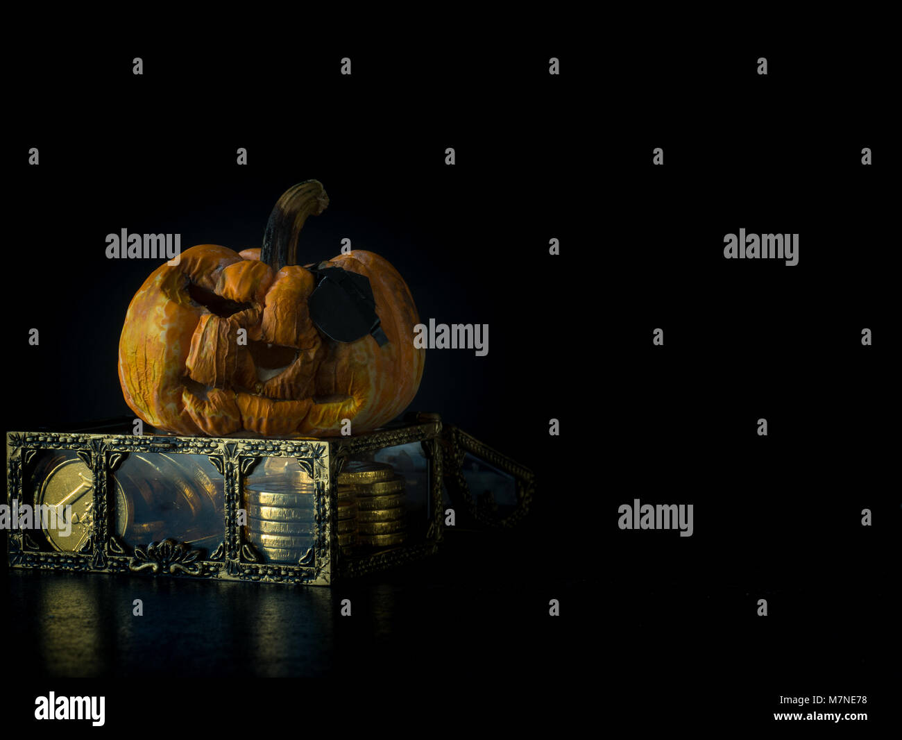 yellow pumpkin have black eye and gold coin on black background Stock ...