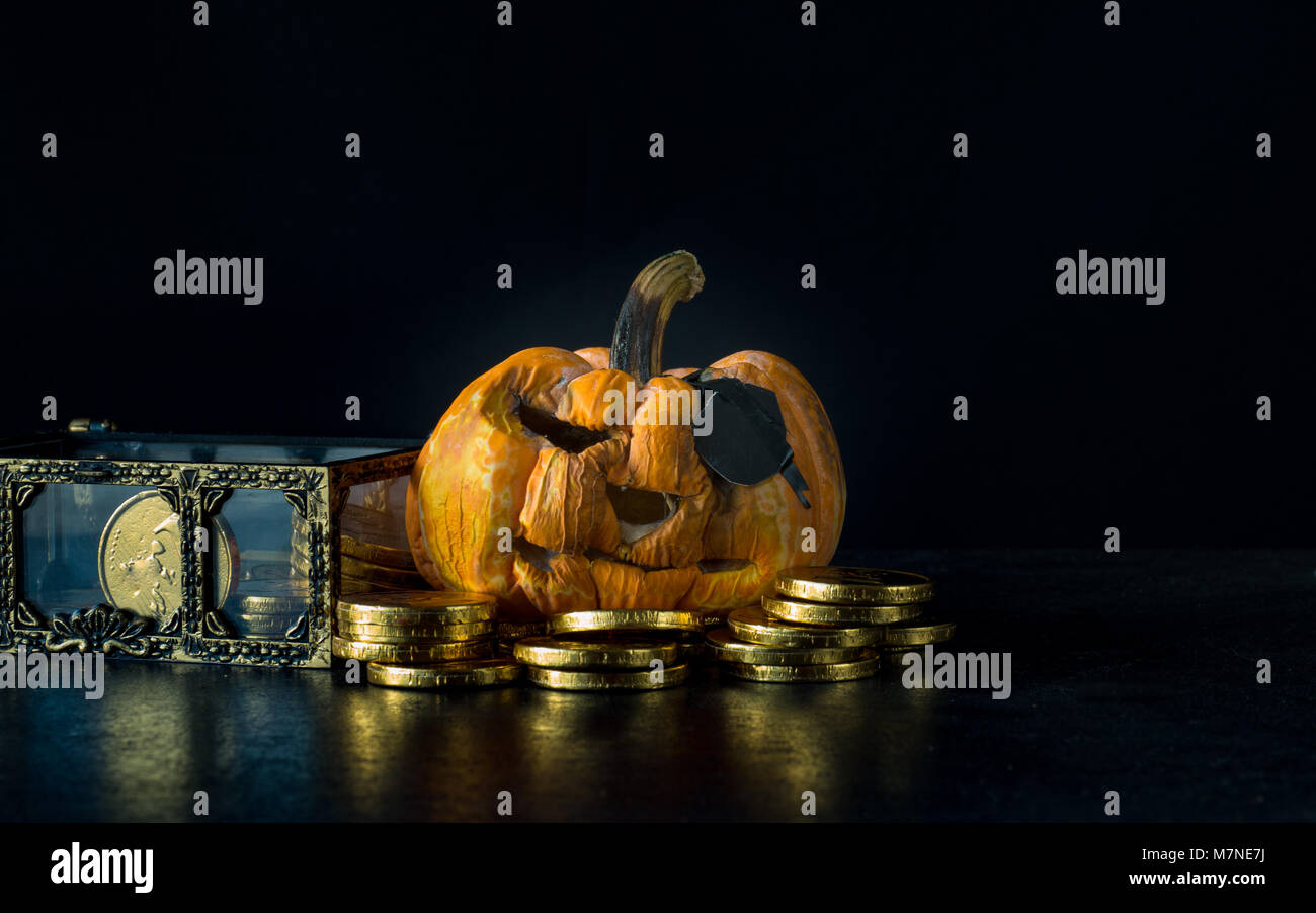 yellow pumpkin have black eye and gold coin on black background Stock ...