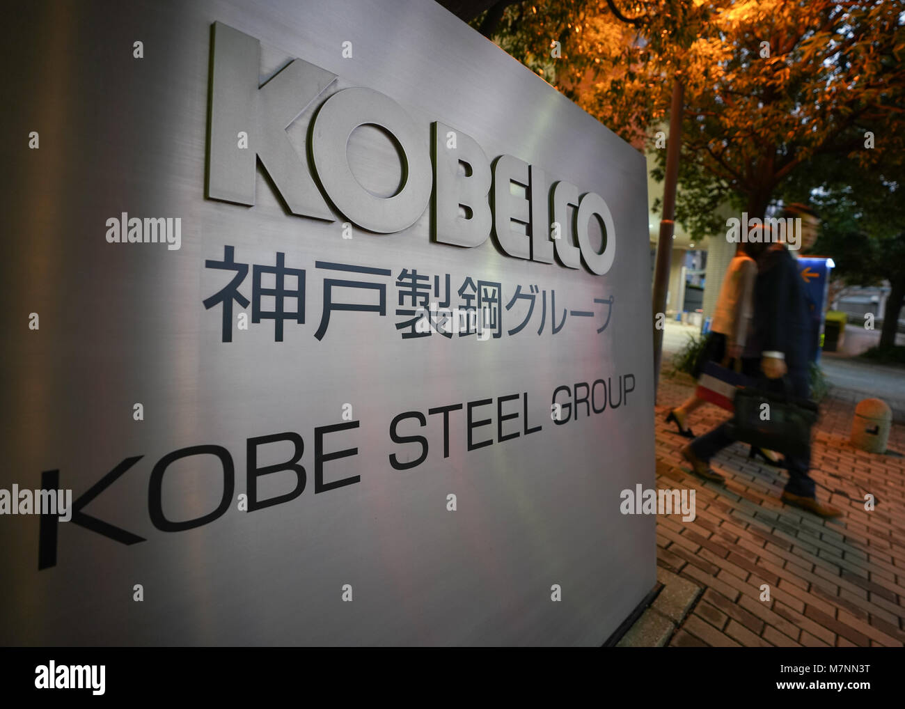 Tokyo, Japan. 9th Mar, 2018. Pedestrians walk past the signboard of ...