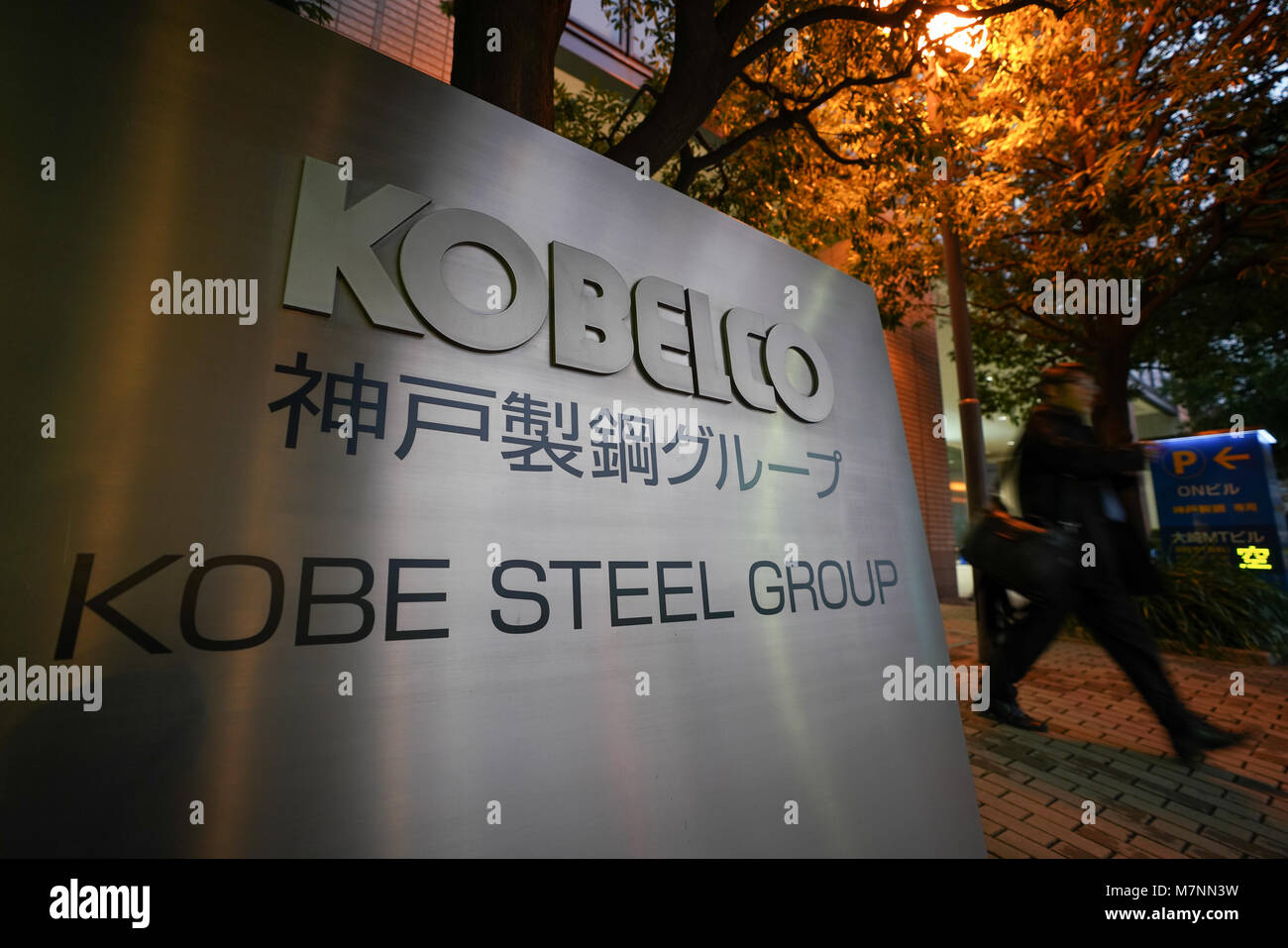 Tokyo, Japan. 9th Mar, 2018. A pedestrian walks past the signboard of ...