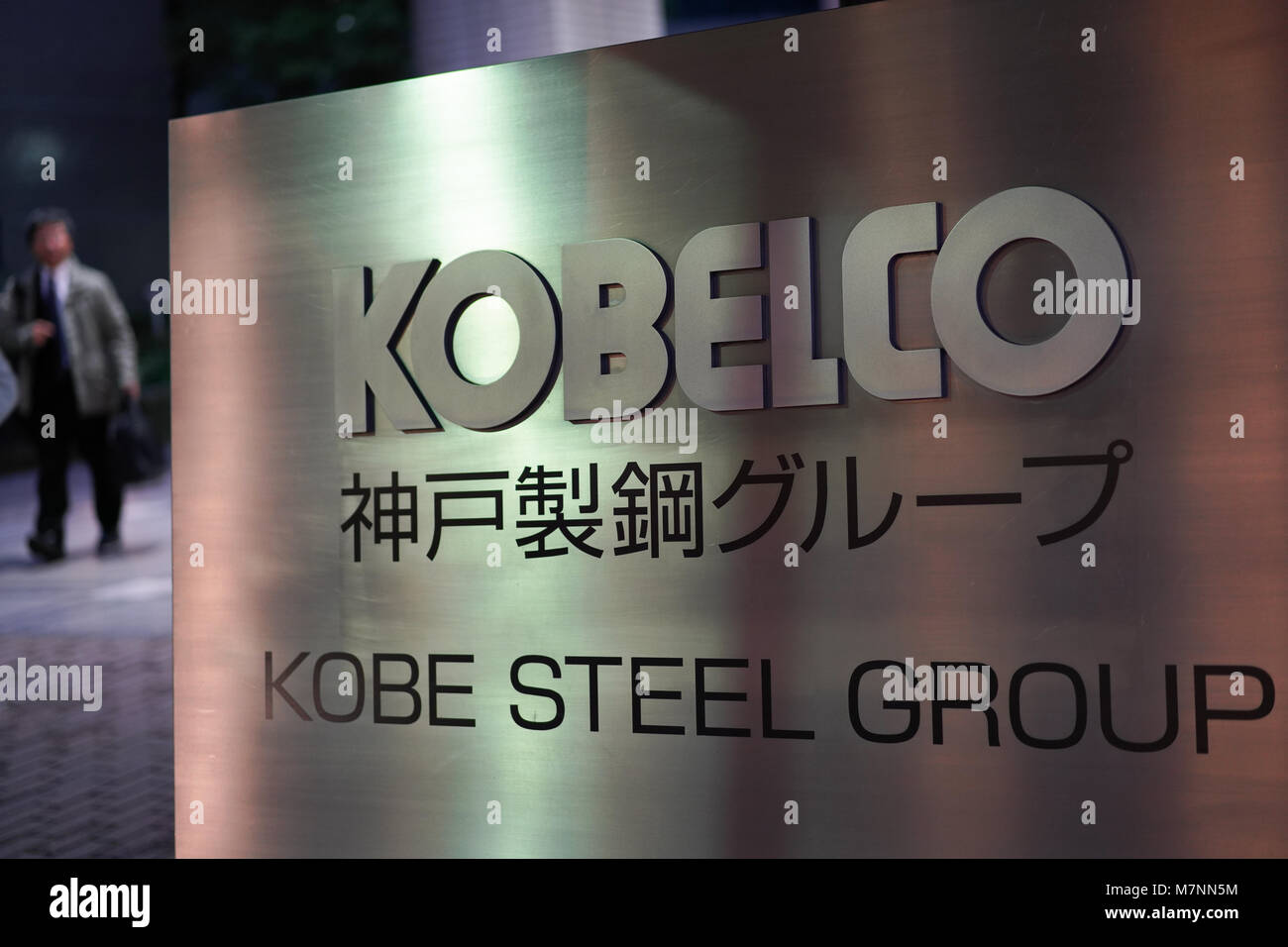 Tokyo, Japan. 9th Mar, 2018. A pedestrian walks past the signboard of ...