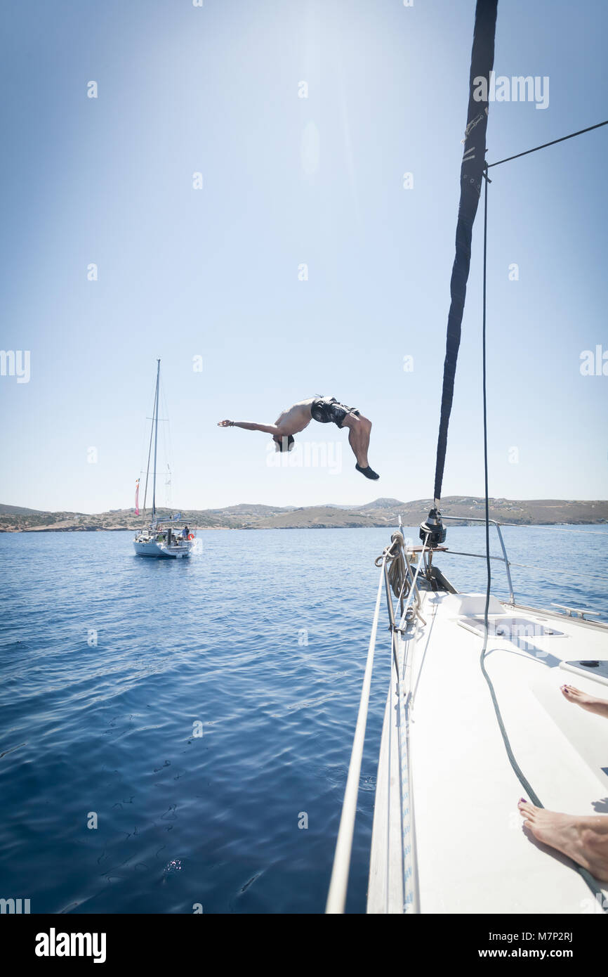 Young man jumping from a boat in the sea Stock Photo - Alamy