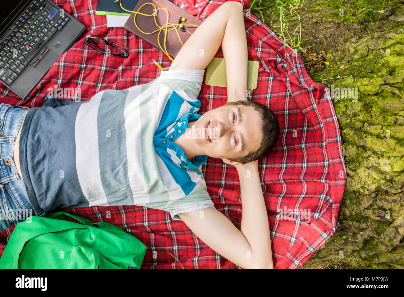 Picture of student lying on rug with notebook Stock Photo - Alamy