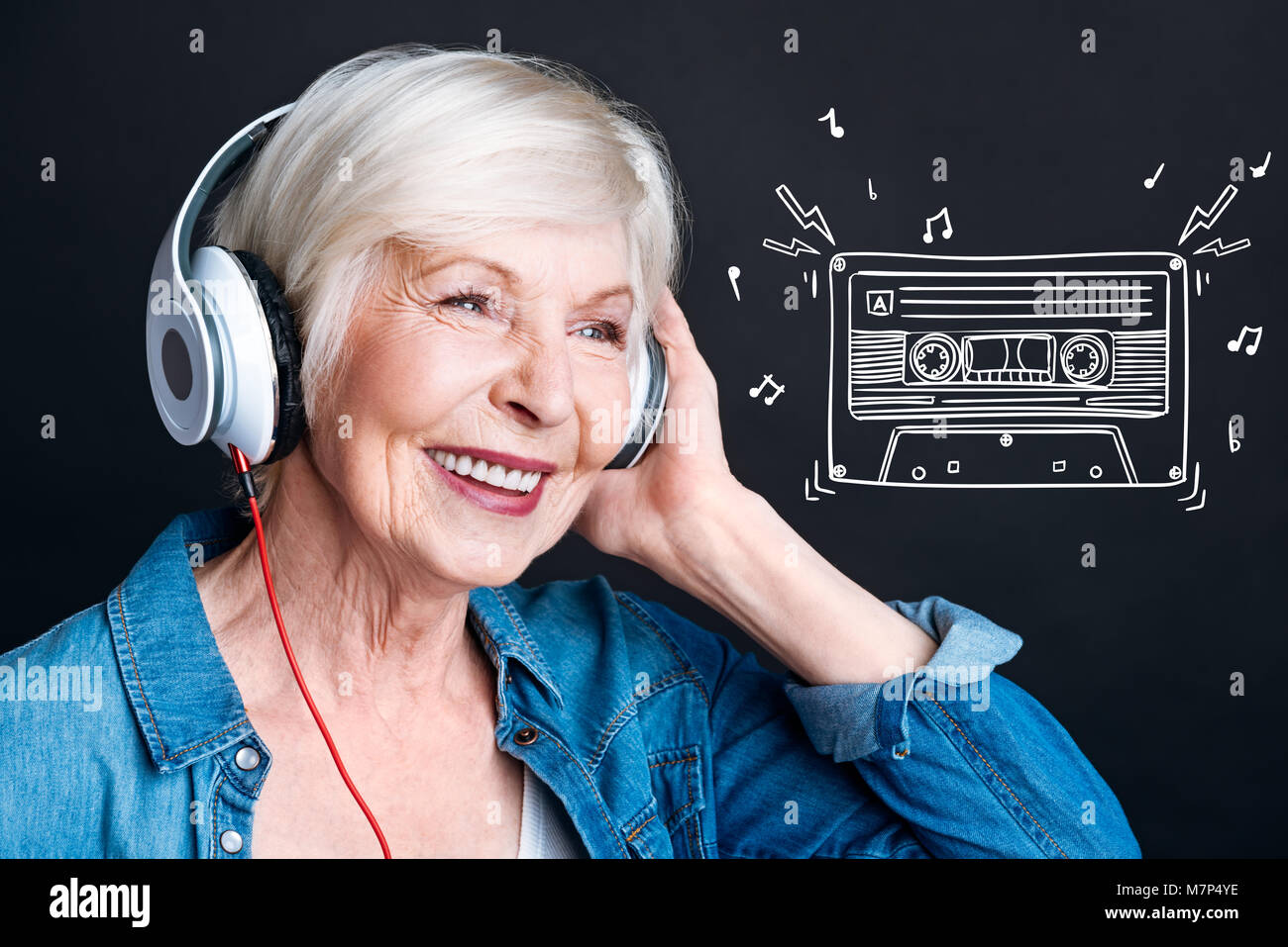 Smiling aged woman feeling happy while listening to loud music Stock ...