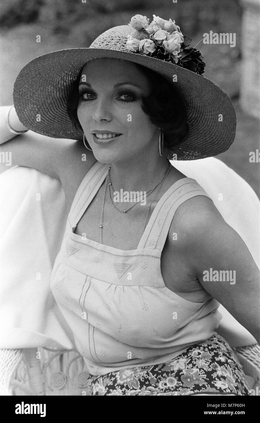 Actress Joan Collins modelling outfits that she will wear on a trip to ...