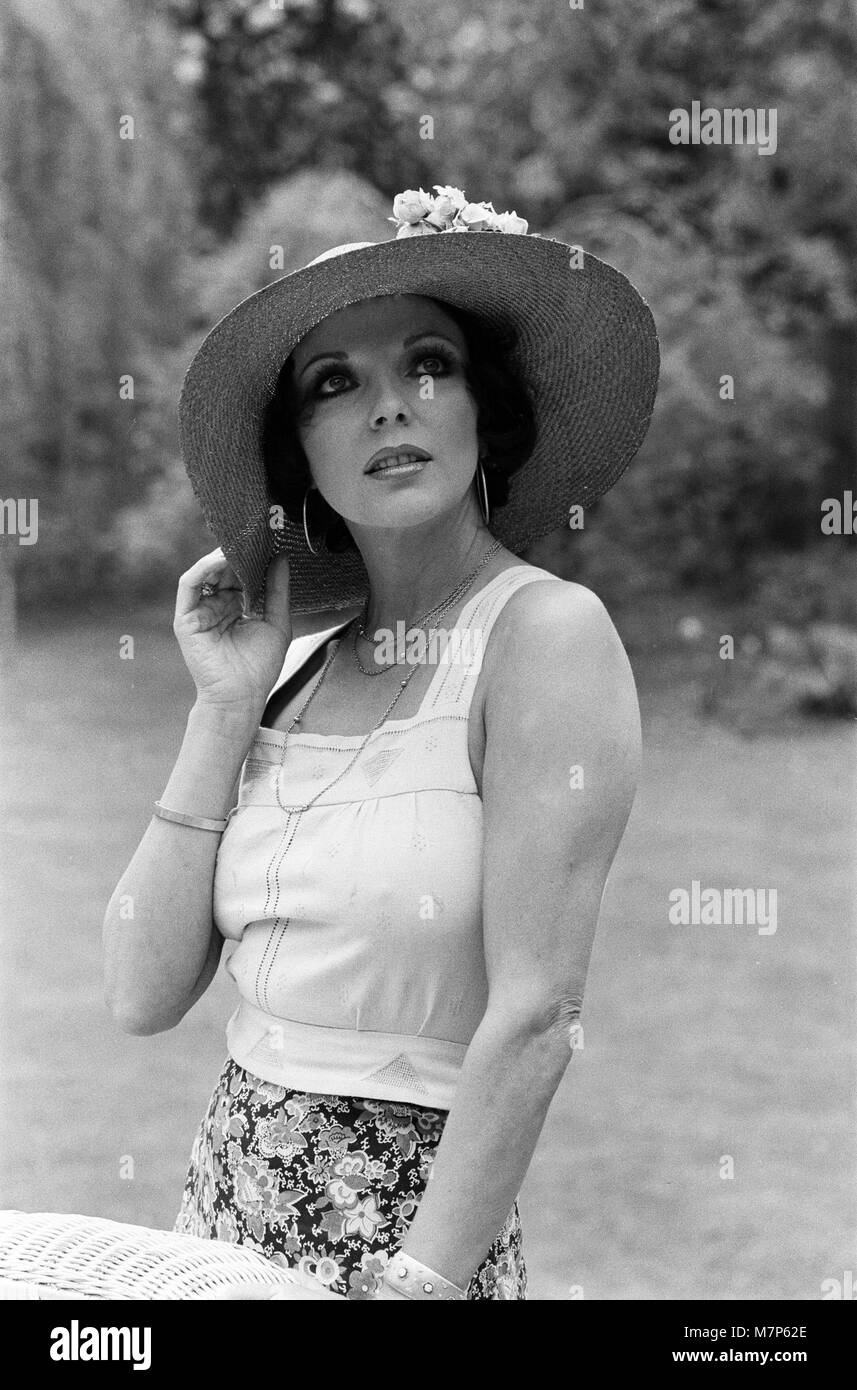 Actress Joan Collins modelling outfits that she will wear on a trip to ...
