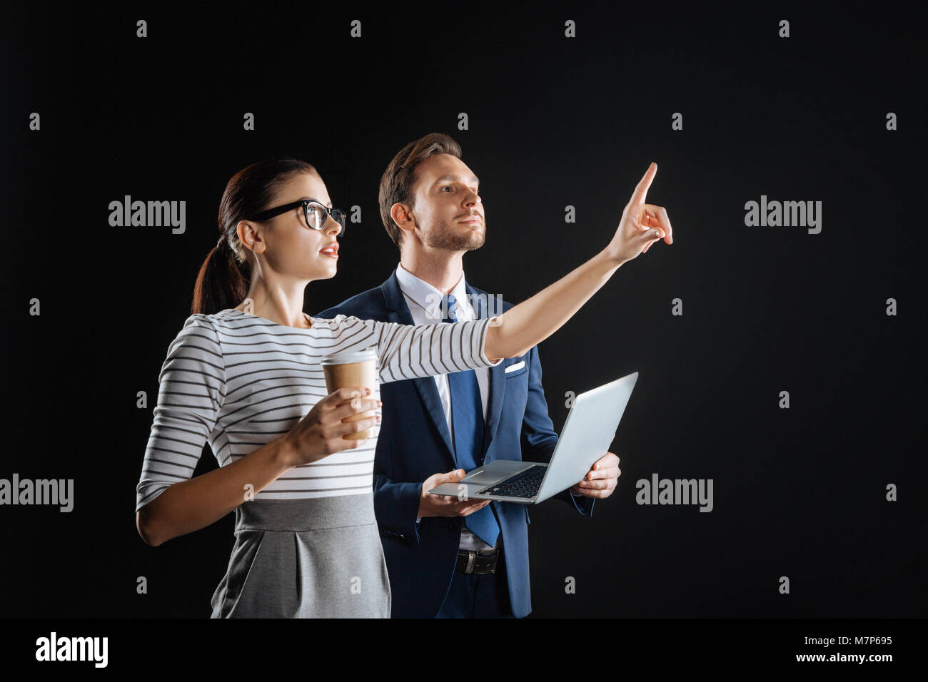 Serious occupied colleagues standing and working together Stock Photo ...