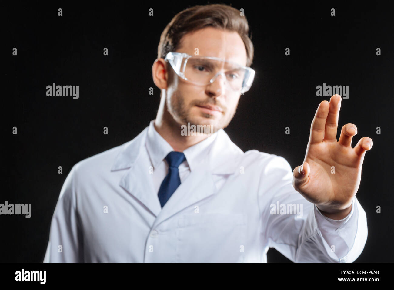 Qualified curious scientist touching to the object looking on it Stock ...