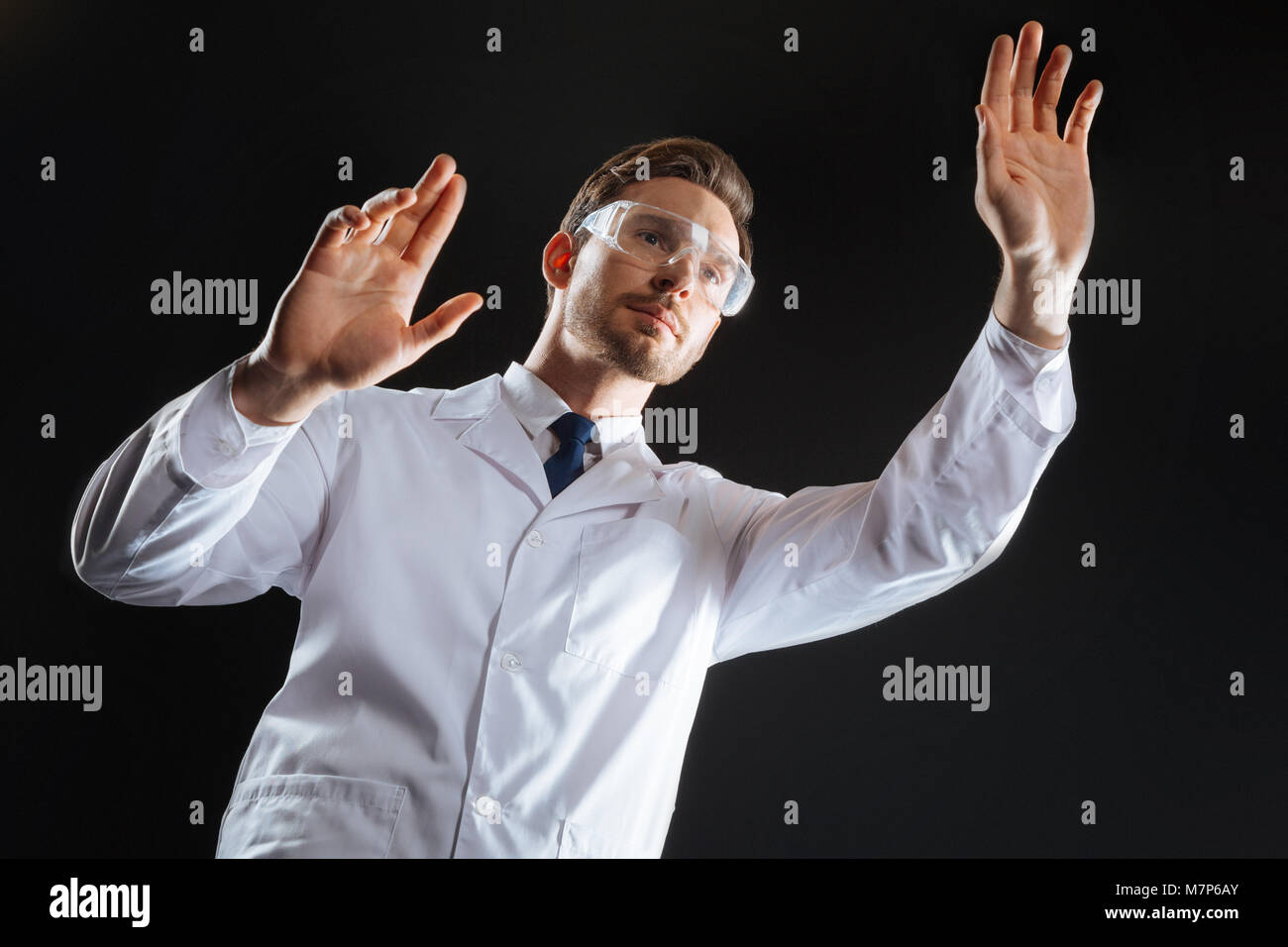 Serious responsible man standing and focusing on his task Stock Photo ...