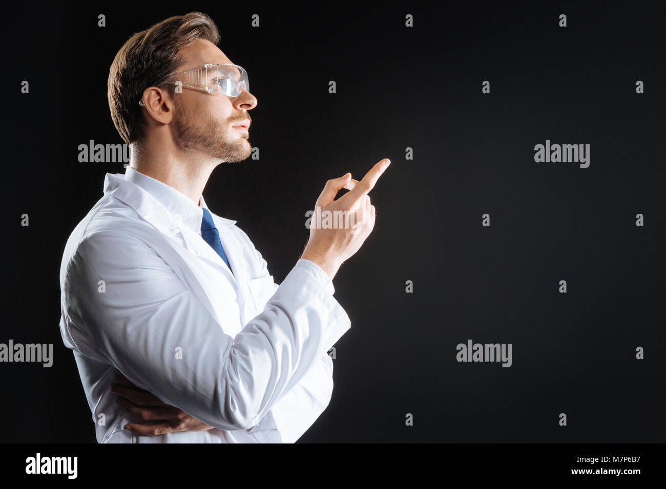 Deep concentrated scientist pointing aside and thinking Stock Photo - Alamy