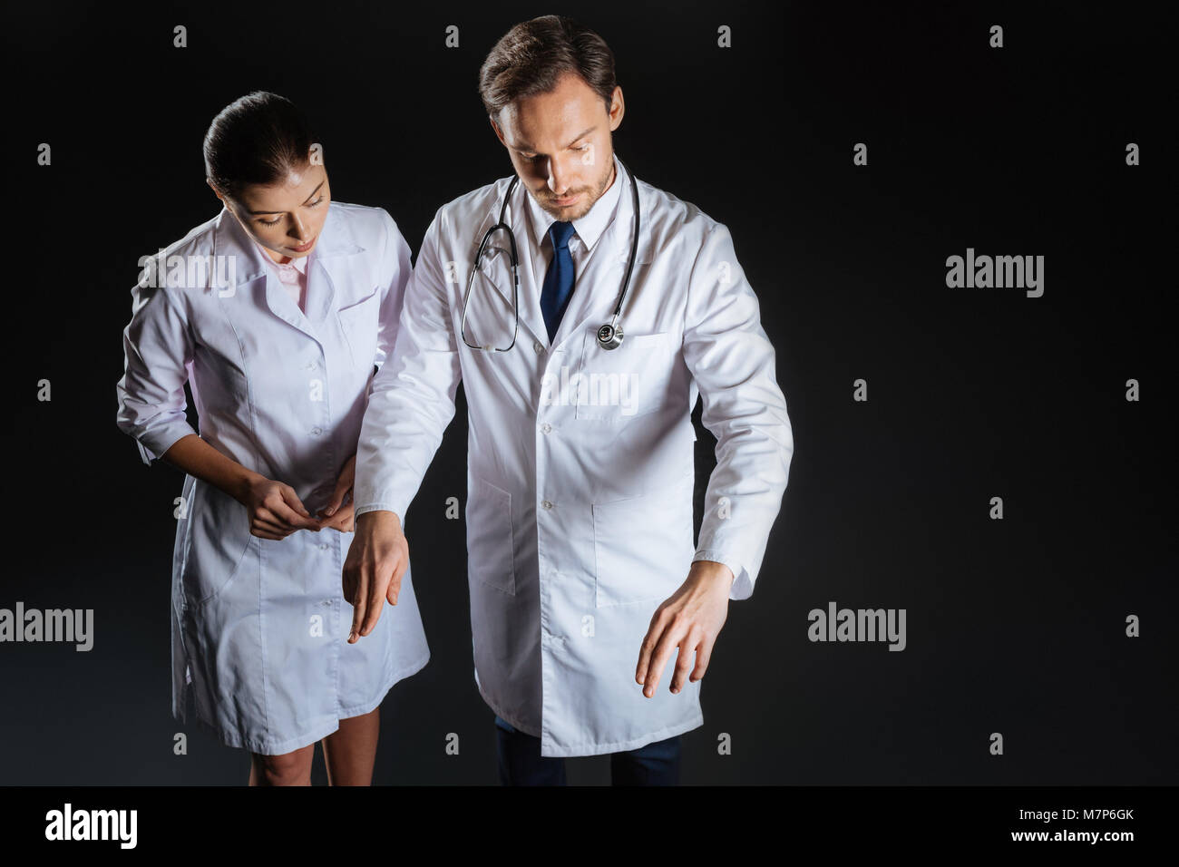 Serious concentrated doctor staying and explaining Stock Photo - Alamy
