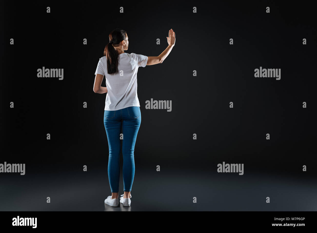 Slim pretty girl standing and holding had up Stock Photo - Alamy