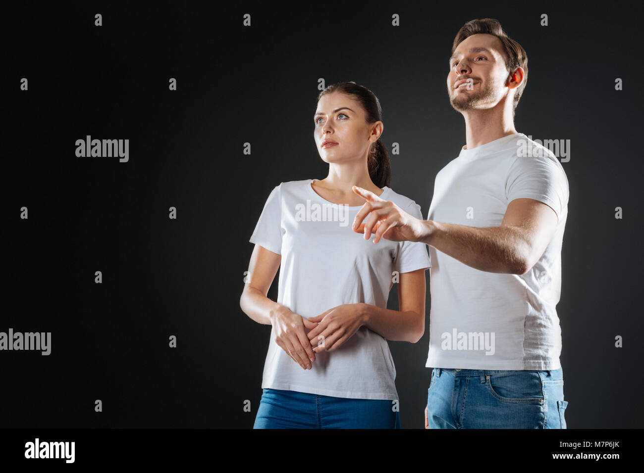 Smiling handsome man standing and pointing aside Stock Photo - Alamy