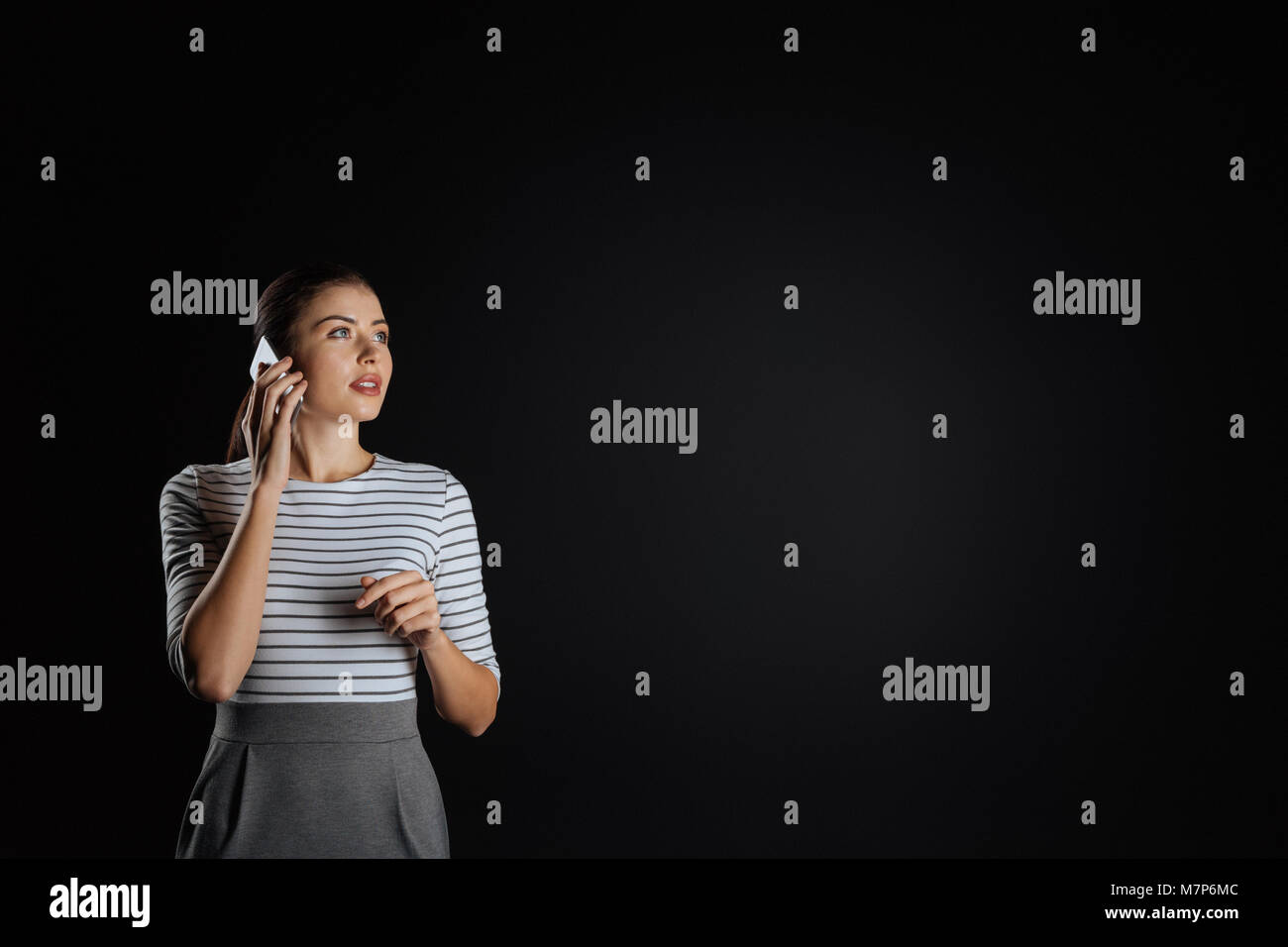 Occupied pretty woman having conversation and looking aside Stock Photo ...