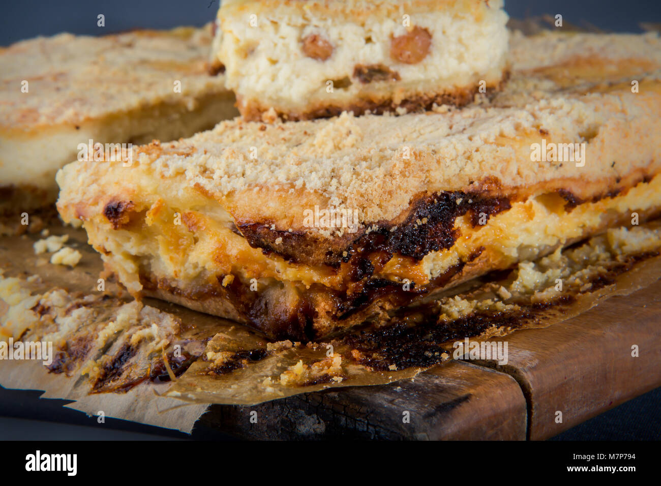 grilled homemade cutted cheesecake with raisins served on wooden tablet ...