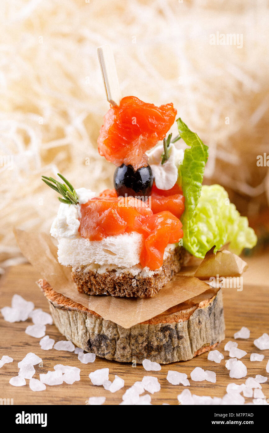 Canape with lightly salted salmon on a cut wood. Rustic. Close-up Stock ...