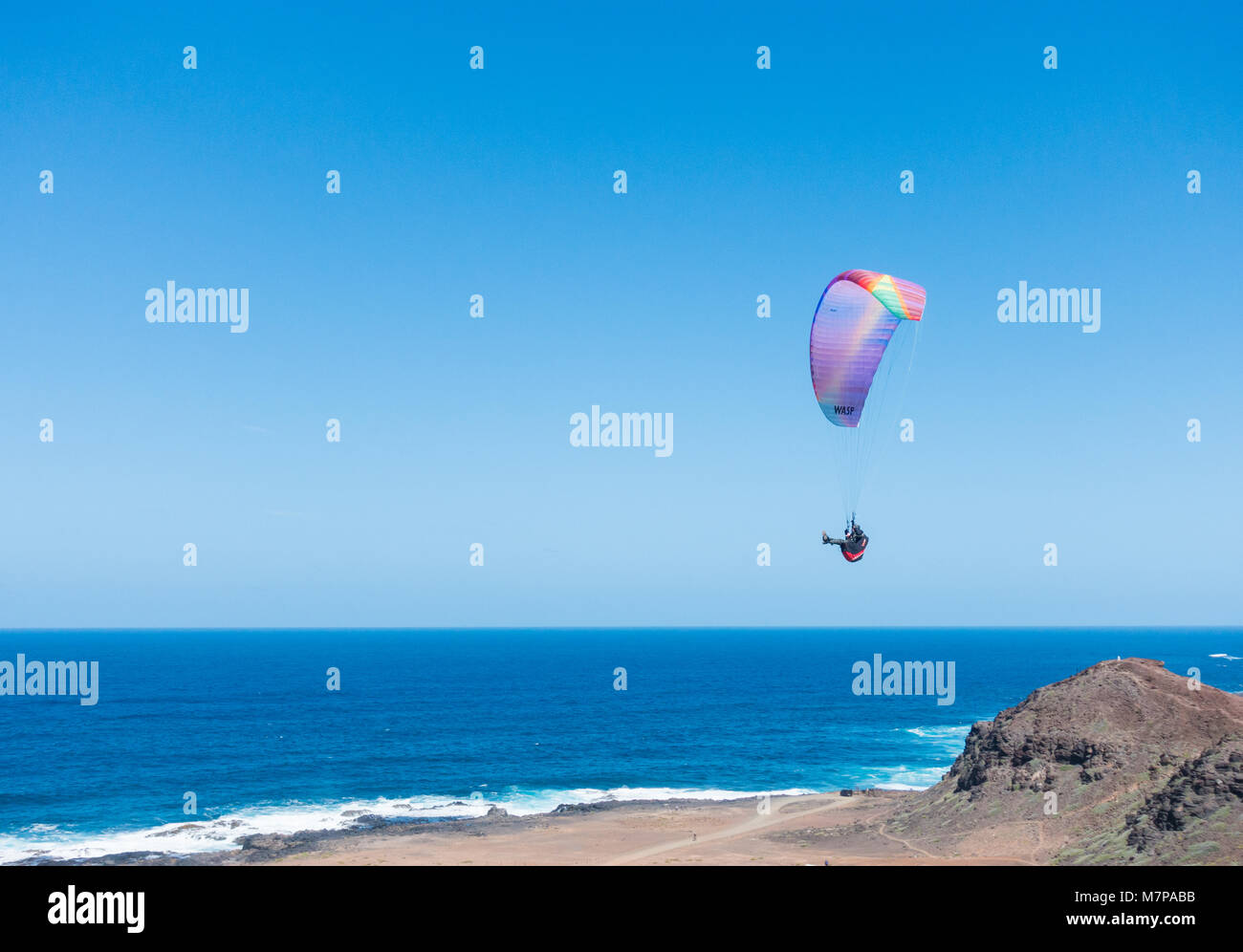 Paraglider taking off from cliff overlooking the Atlantic Ocean ...