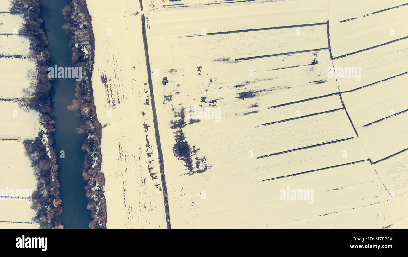 Drop down view of river passing snow covered fields Stock Photo - Alamy