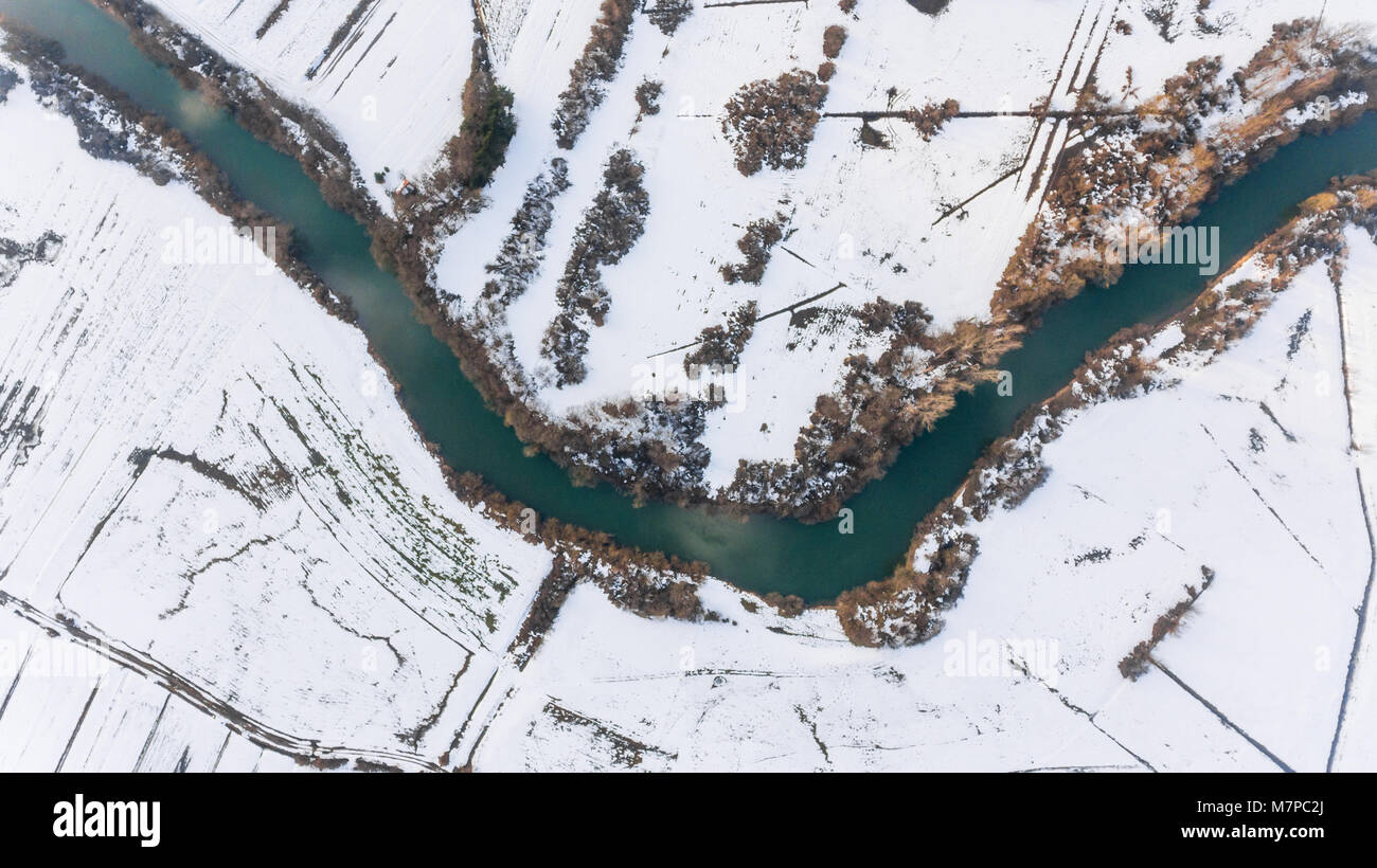 Aerial view riverbend passing snow covered fields Stock Photo - Alamy