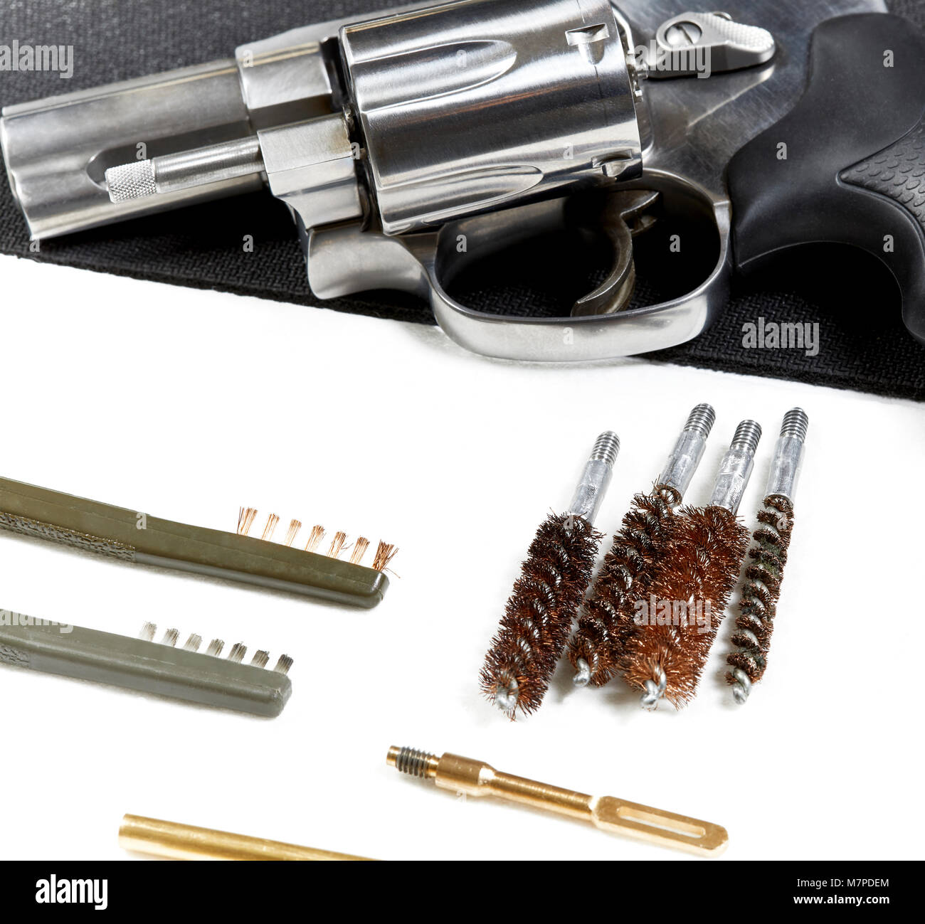 Snubnose revolver laying on table with gun cleaning tools isolated on a ...