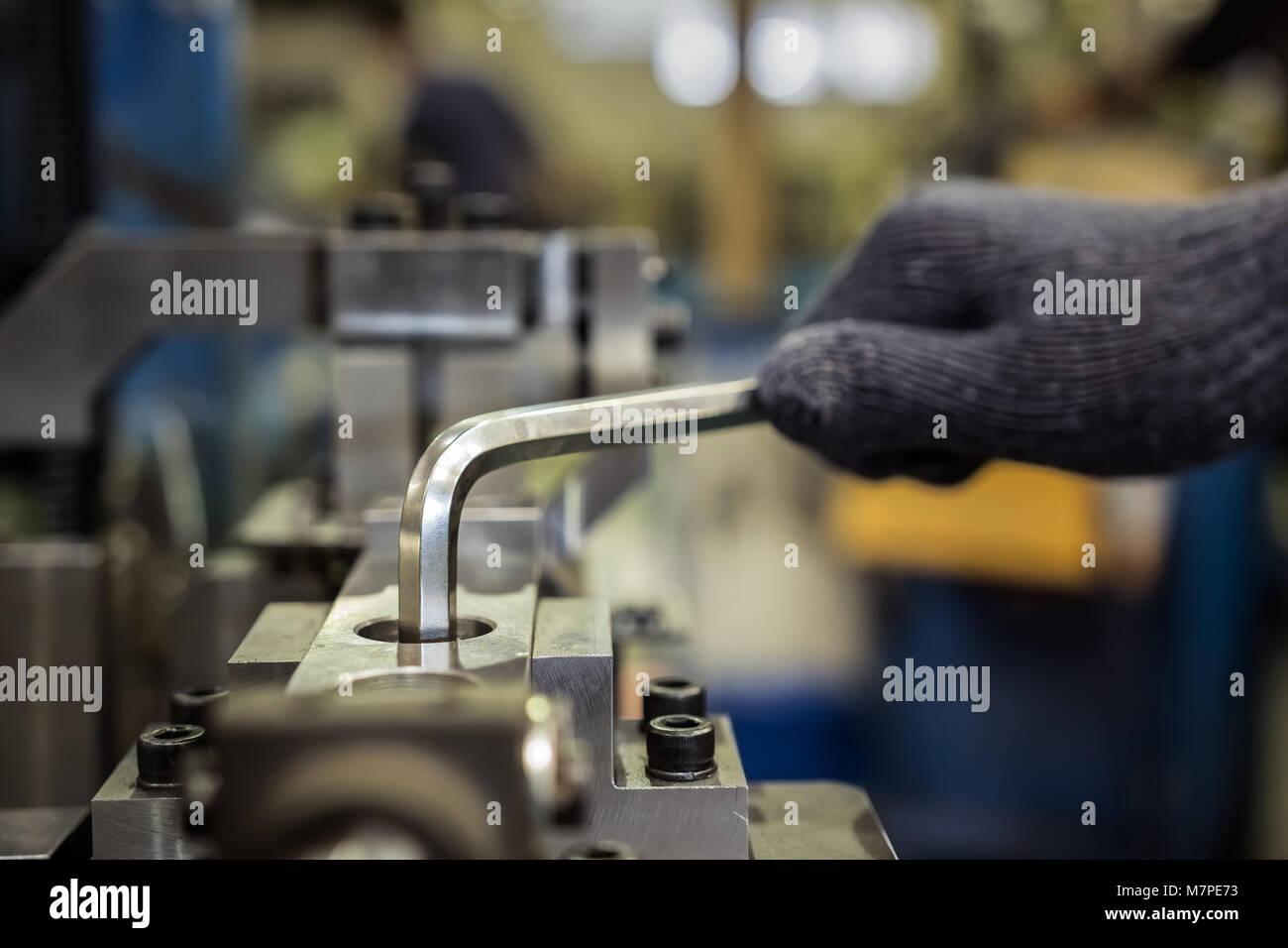 Worker is used Hexagonal screwdriver in factory Stock Photo - Alamy