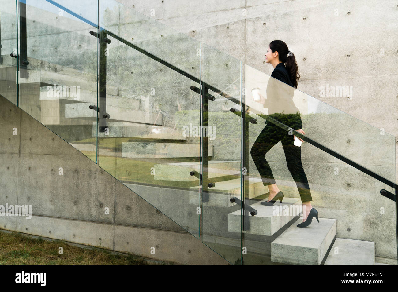 successful young business manager walking up to stair outside of the ...